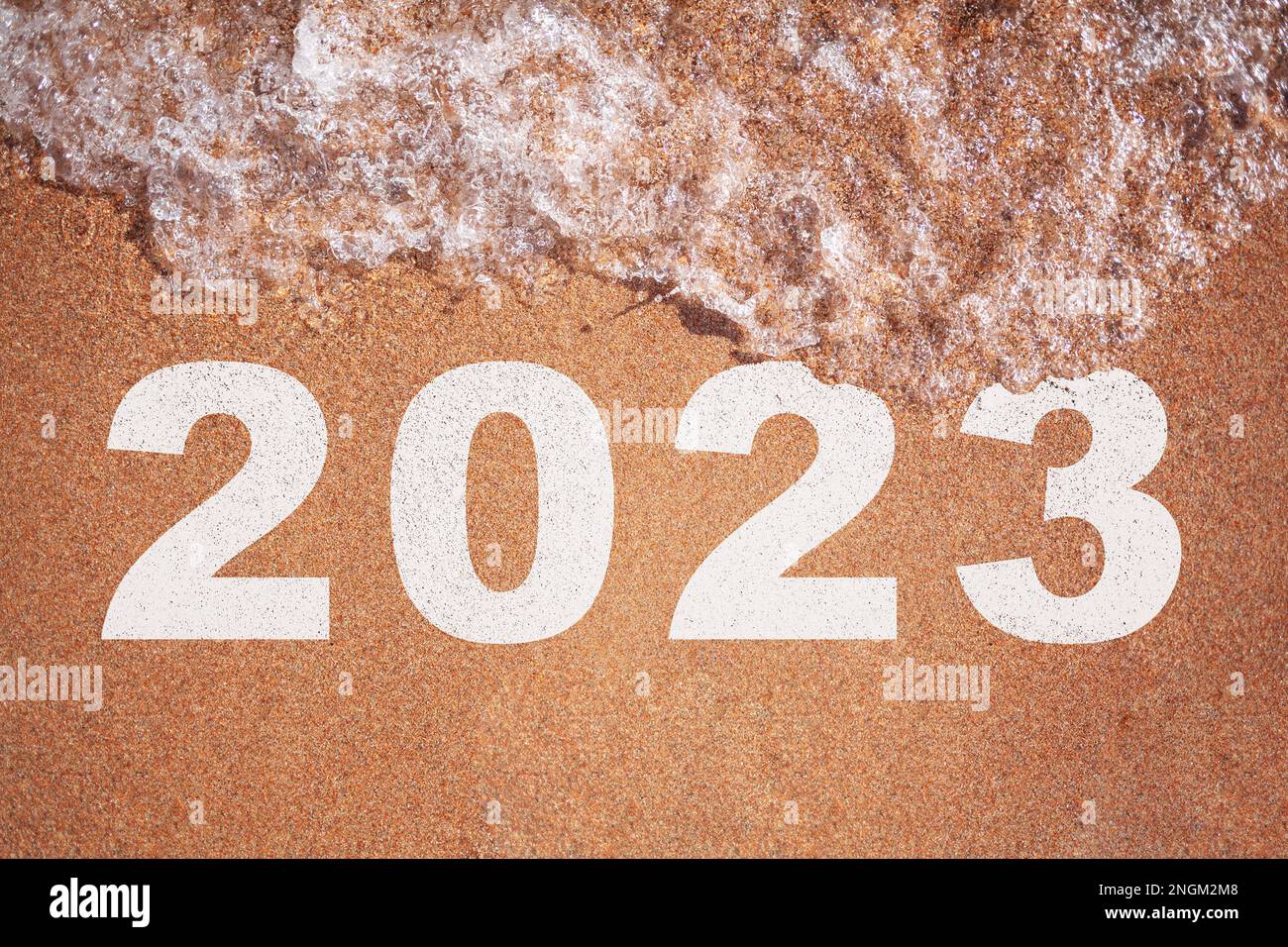 Year 2023 handwriting on sand beach surface Stock Photo - Alamy
