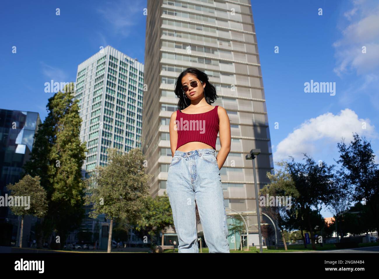 Portrait in the city of a serious asian woman standing looking at ...