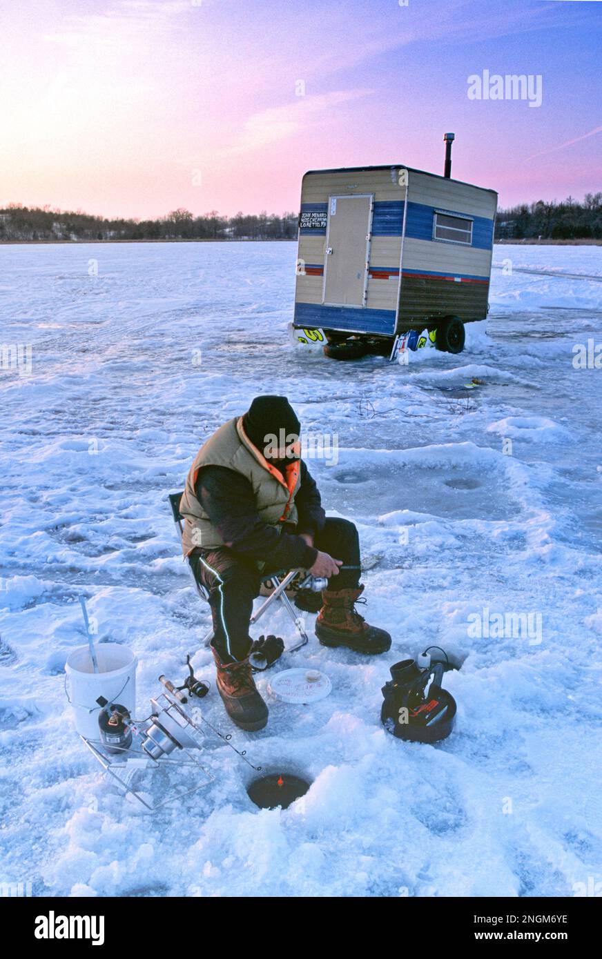 A dedicated man ice fishing on a frozen Minnesota lake Stock Photo - Alamy