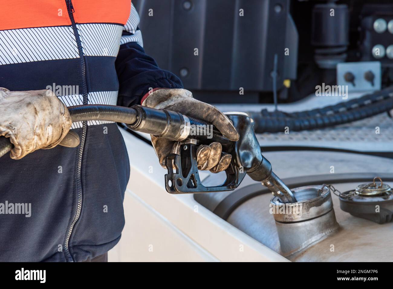 Truck driver with a pump nozzle in his hands filling the vehicle's fuel ...