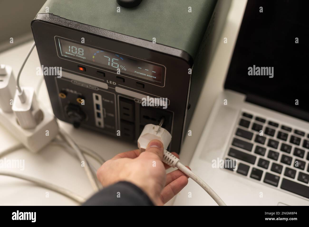Portable power station charging gadgets on table in room Stock Photo ...