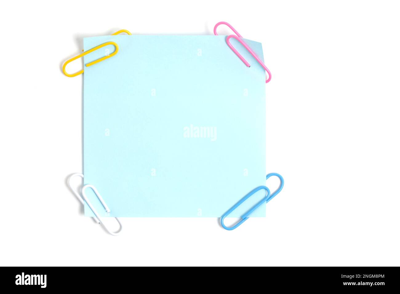 Blue paper sticker for written notes and paper clips on a white ...