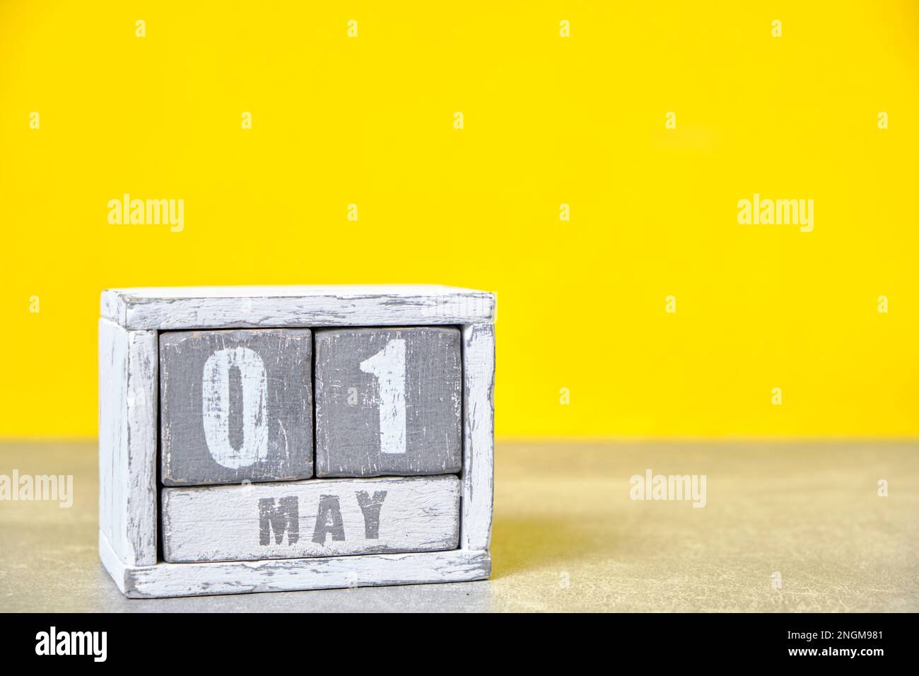 May 1, Wooden desktop calendar yellow background.Spring month depicted ...