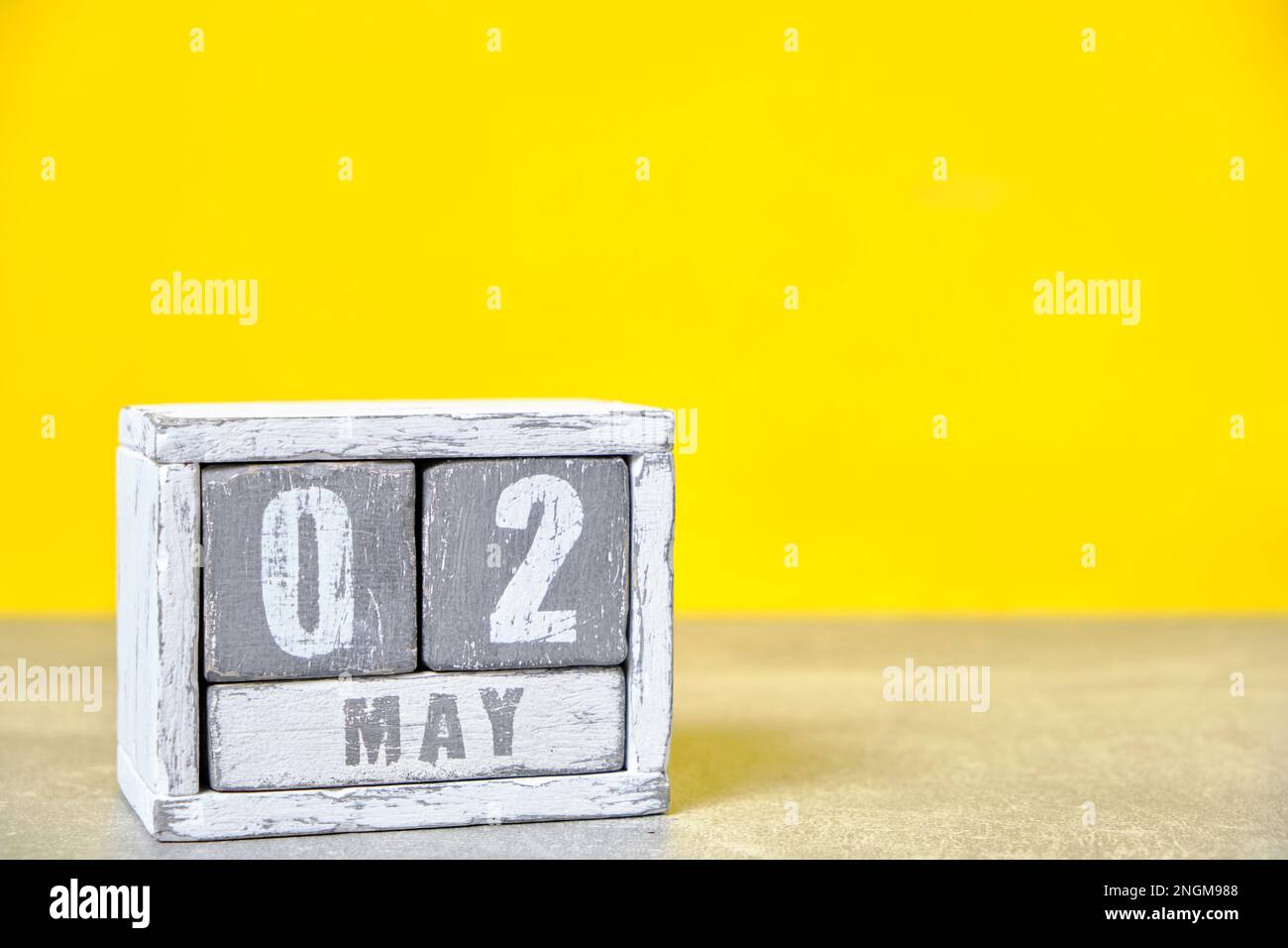 May 2, Wooden desktop calendar yellow background.Spring month depicted ...