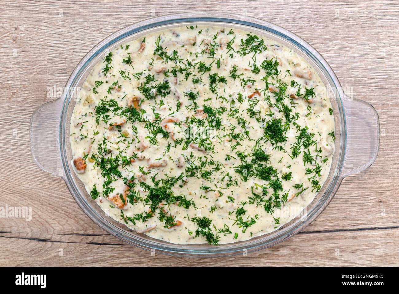Baked pieces of fish fillet in chanterelle cream sauce in a glass bowl ...