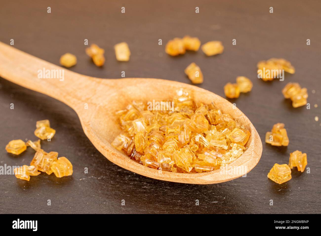 Yellow gelatin granules with wooden spoon on slate stone, macro Stock ...