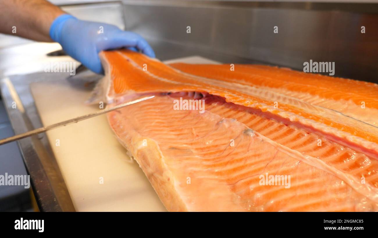 Cutting fresh raw Norwegian salmon fish in store Stock Photo - Alamy
