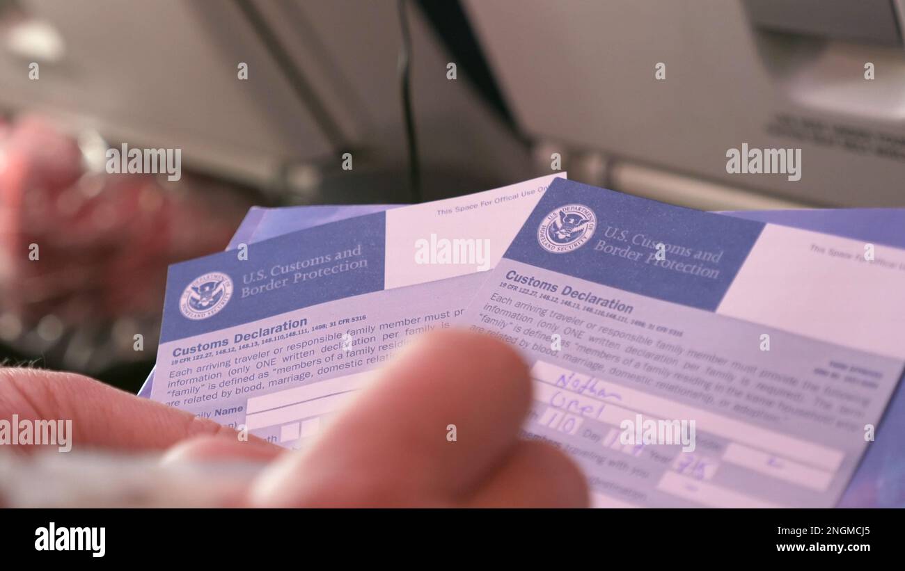 Man filling out US customs declaration forms before entering the USA ...