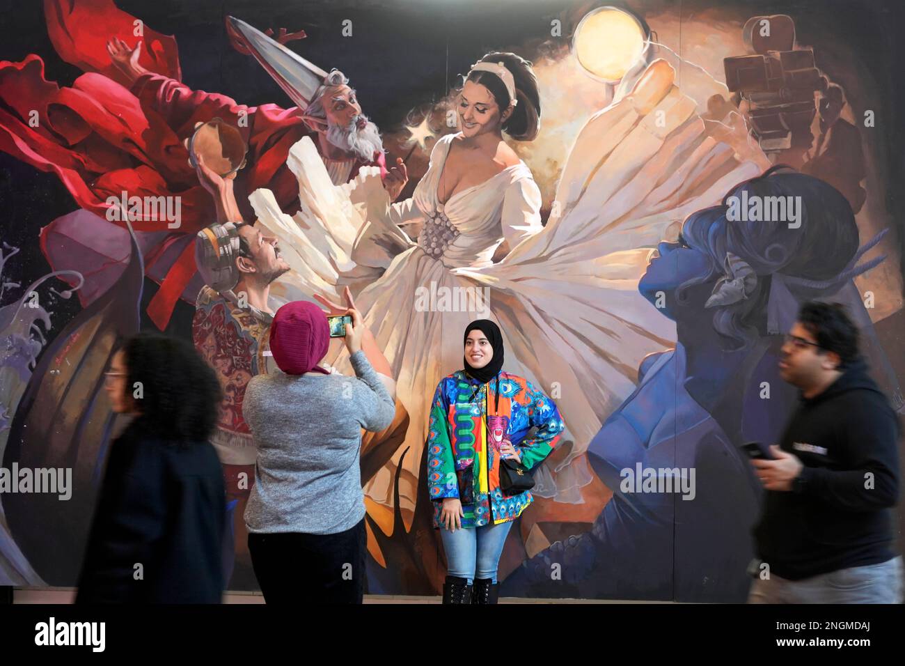 Visitors pose in front of the painting of Egyptian artist Marwan Sabra ...