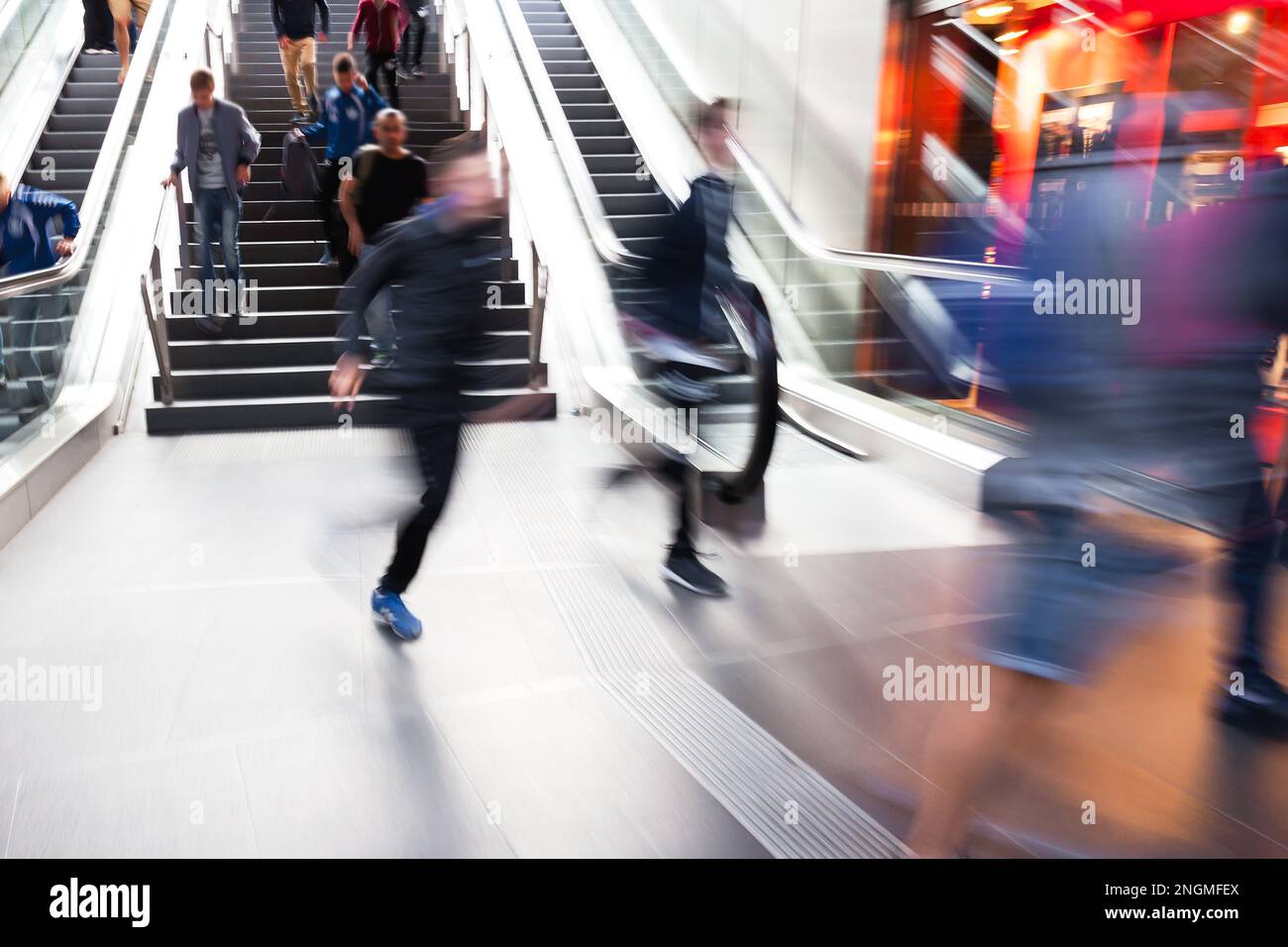 picture with motion blur effect of people rushing down an escalator to ...