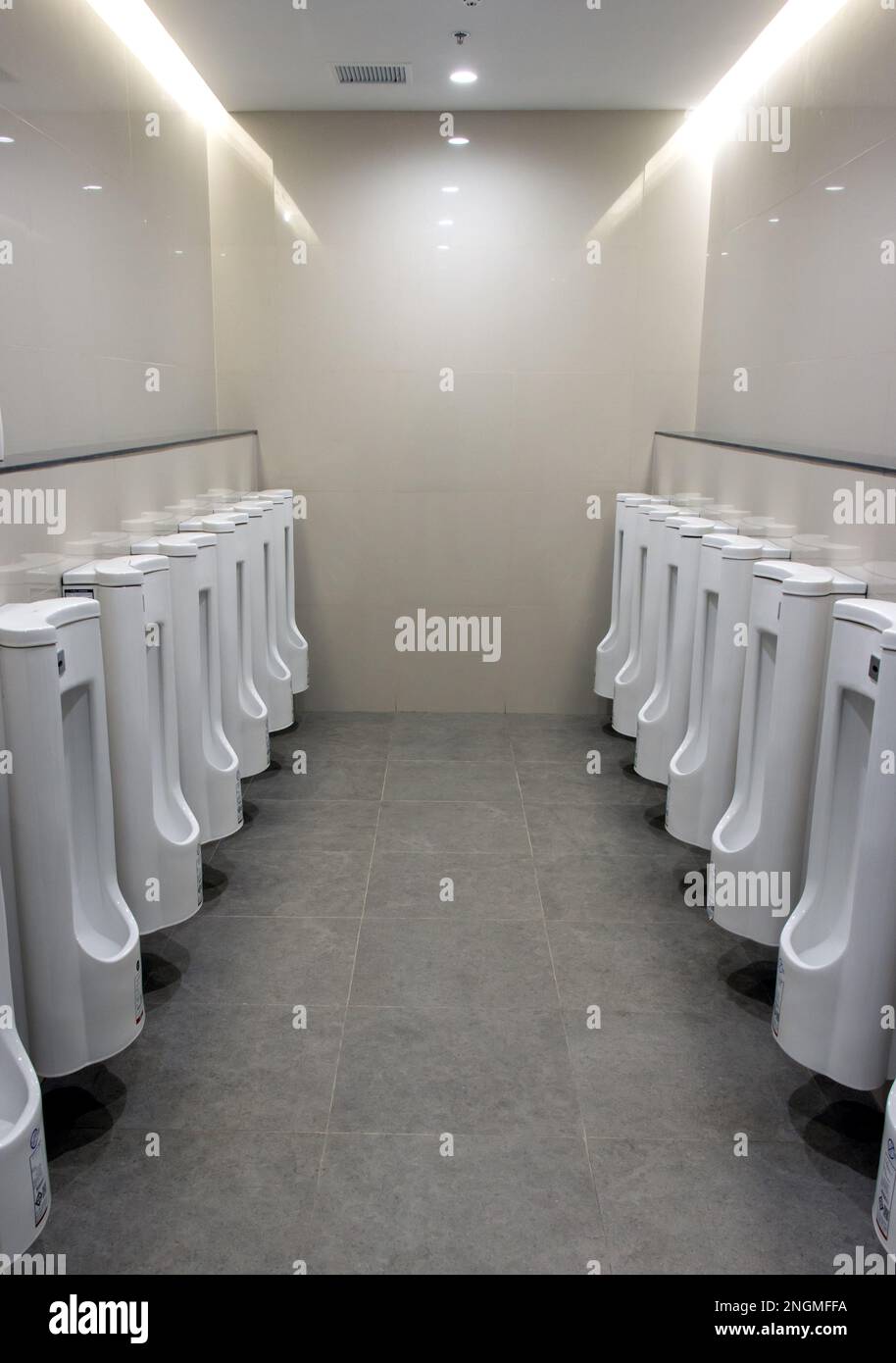 Interior of men's toilets with two rows of urinals Stock Photo - Alamy