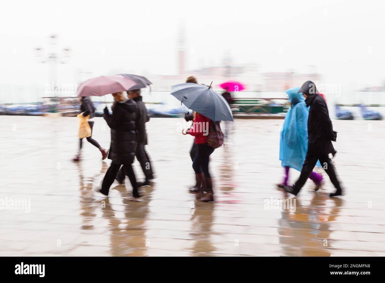 picture with camera made motion blur effect of people with umbrellas ...