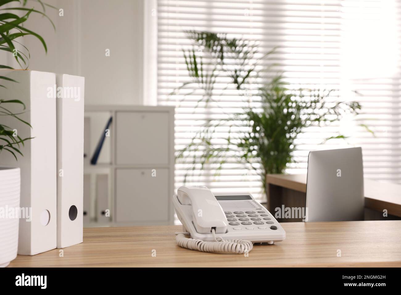 Telephone on wooden desk at hospital reception Stock Photo - Alamy