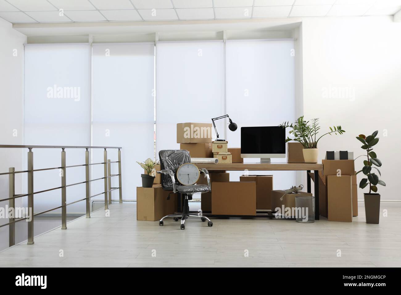 Cardboard boxes, computer and furniture in new office. Moving day Stock ...