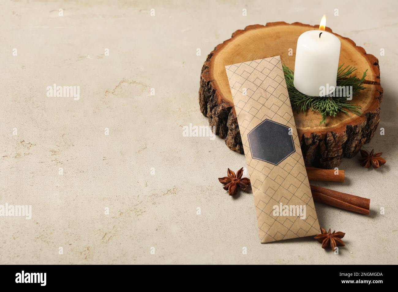 Scented sachet, burning candle and spices on grey table, space for text ...
