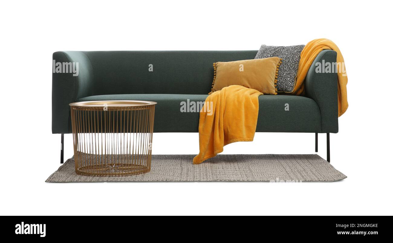 Comfortable green sofa with cushions, blanket and table on white ...