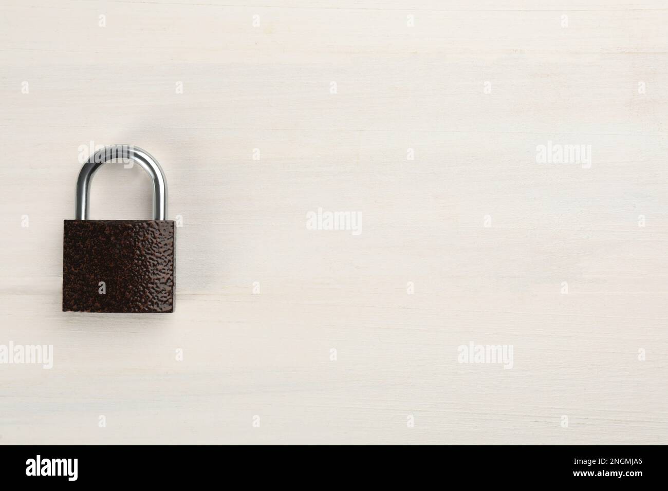 Modern padlock on white wooden table, top view. Space for text Stock ...