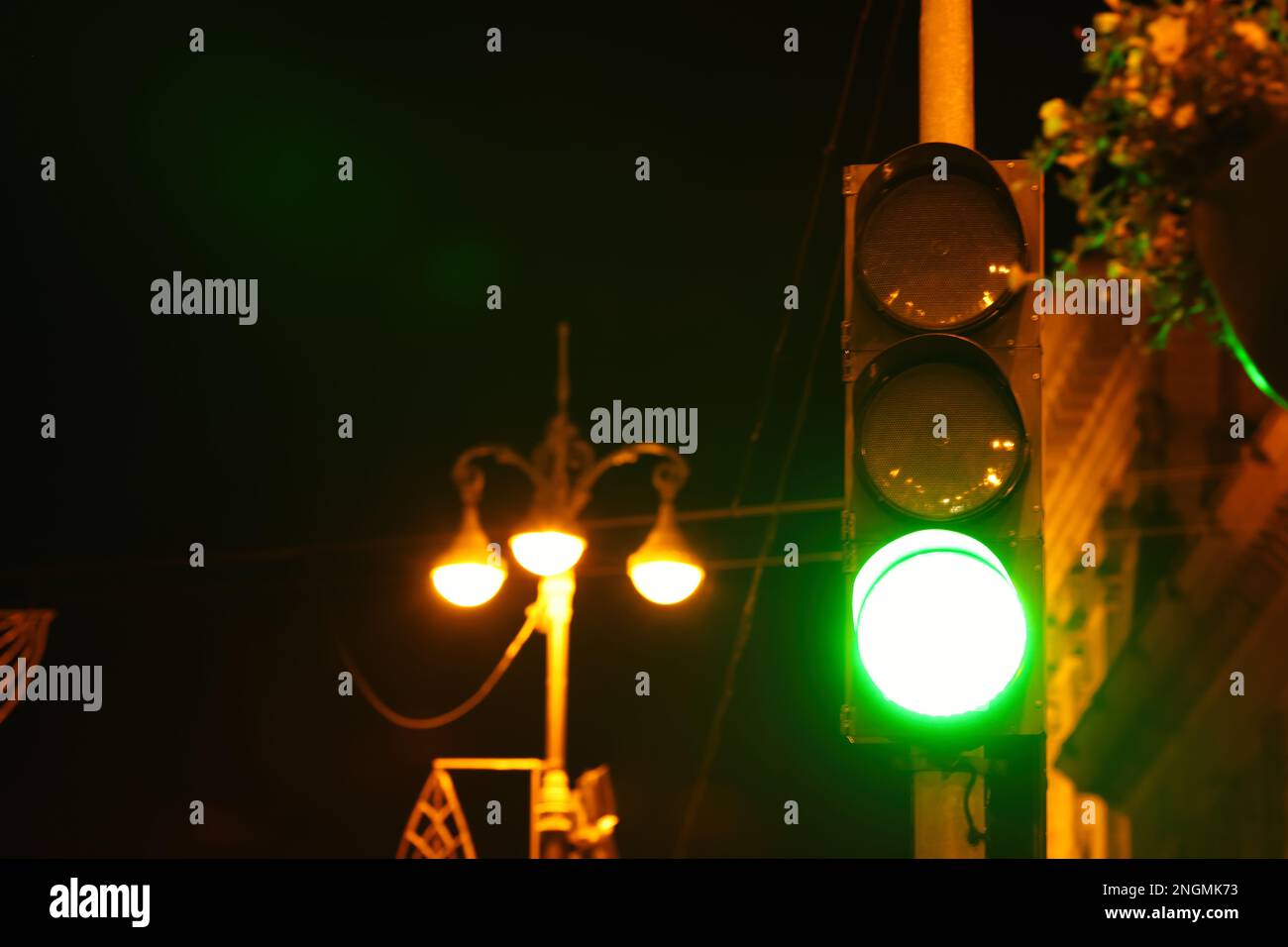 Green traffic light in city at night, space for text Stock Photo - Alamy