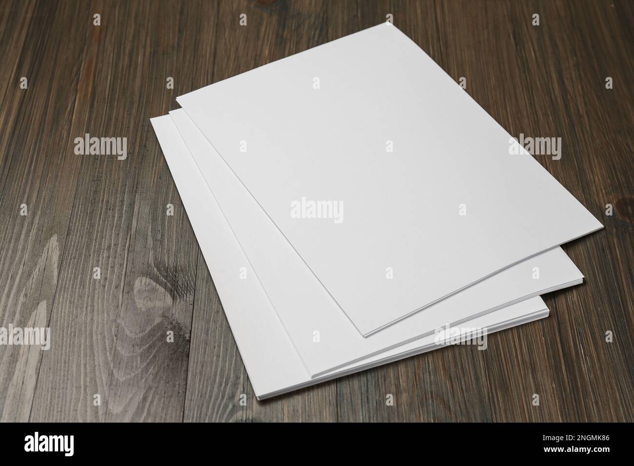 Stack of blank paper sheets on wooden table. Brochure design Stock ...