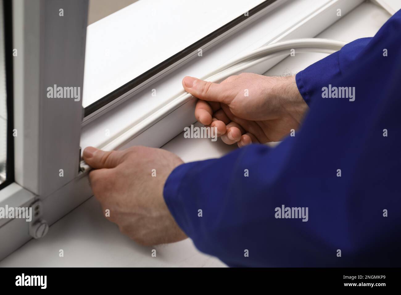 Worker putting rubber draught strip onto window indoors, closeup Stock ...