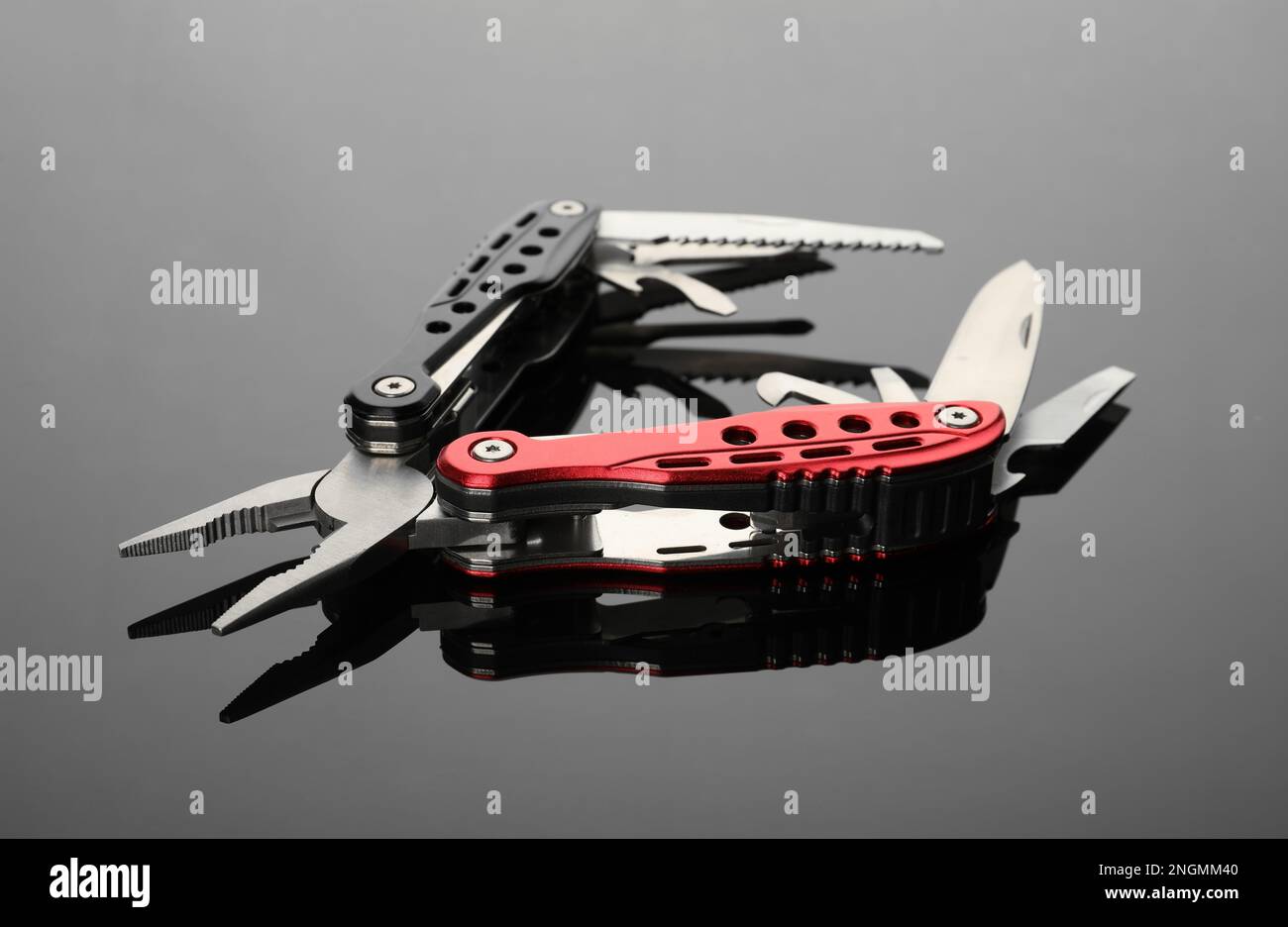 Modern compact portable multitool on grey table Stock Photo - Alamy