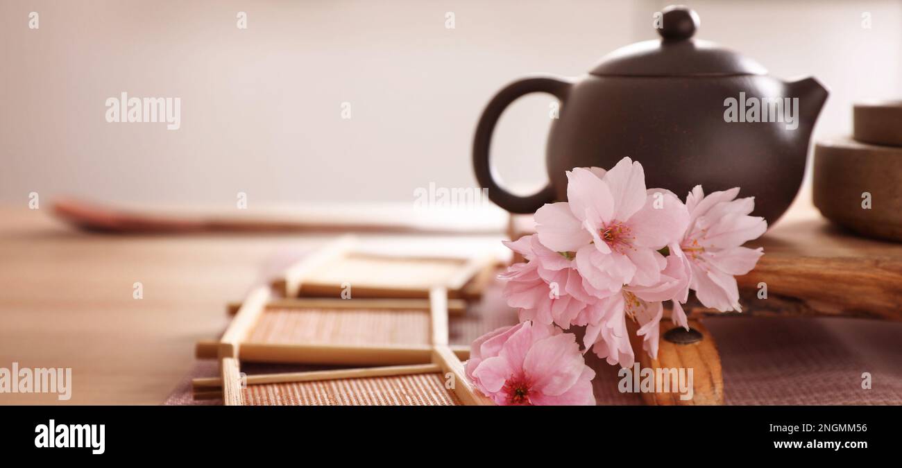 Pot, sakura flowers and bamboo coasters for traditional tea ceremony on ...