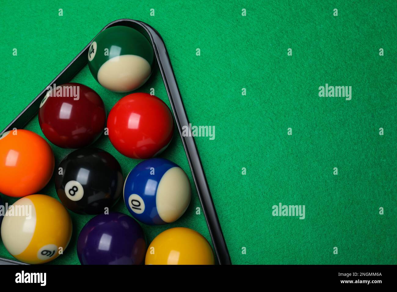 Plastic rack with billiard balls on green table, top view. Space for ...