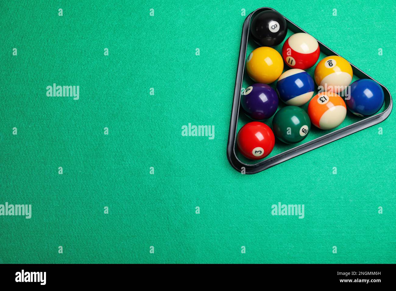 Plastic rack with billiard balls on green table, top view. Space for ...