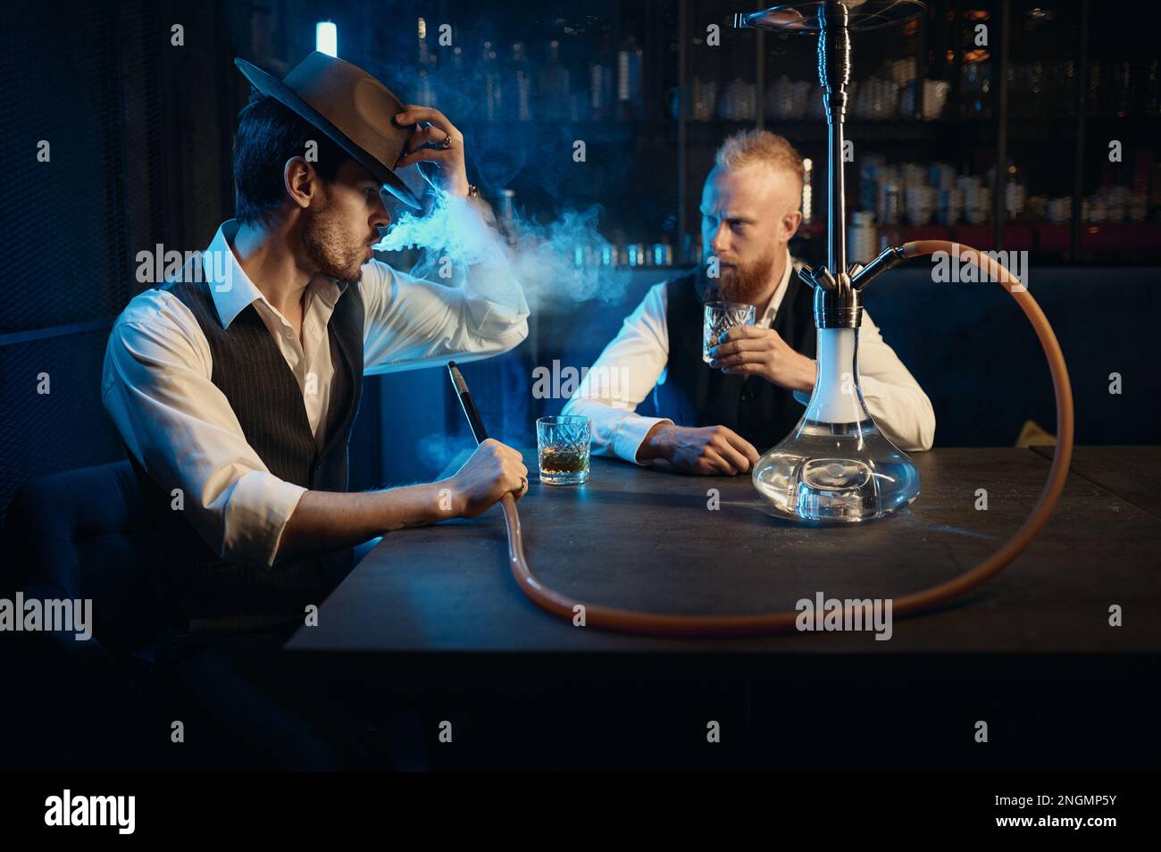 Stylish gangsters smoking hookah in bar having business meeting Stock ...
