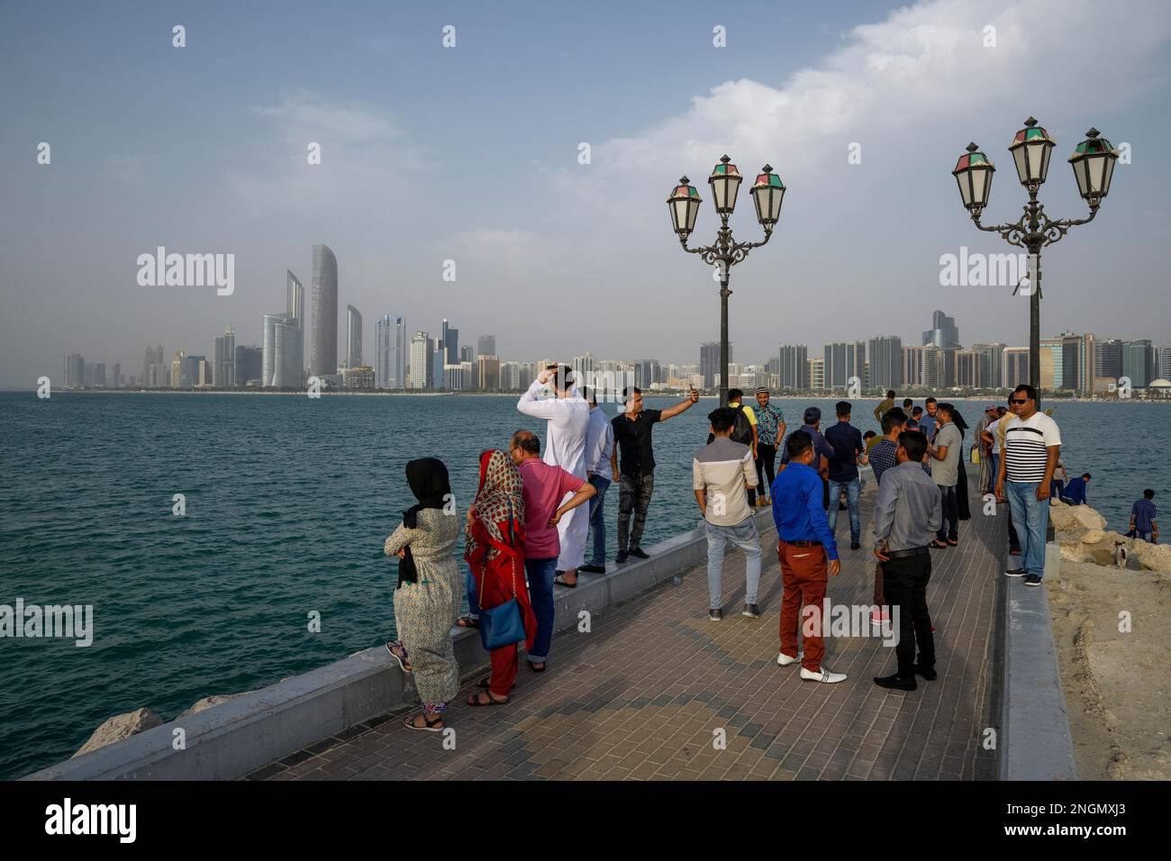 Locals in front of skyline at Wave Breaker Beach vantage point, Abu ...