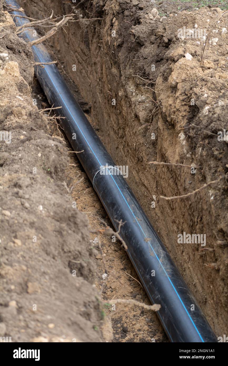 Plastic sewer pipe in trench for laying an external sewage system at a ...
