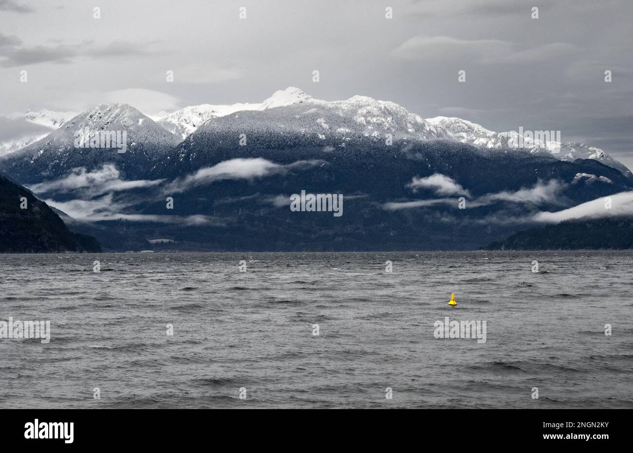 A cold mountain sea view with yellow buoy looking across Howe Sound north of Vancouver Stock ...