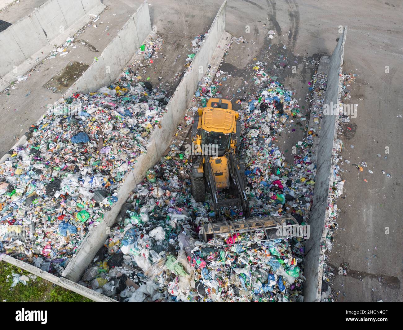 Skid steer loader moving plastic garbage with scrap grapple on the ...