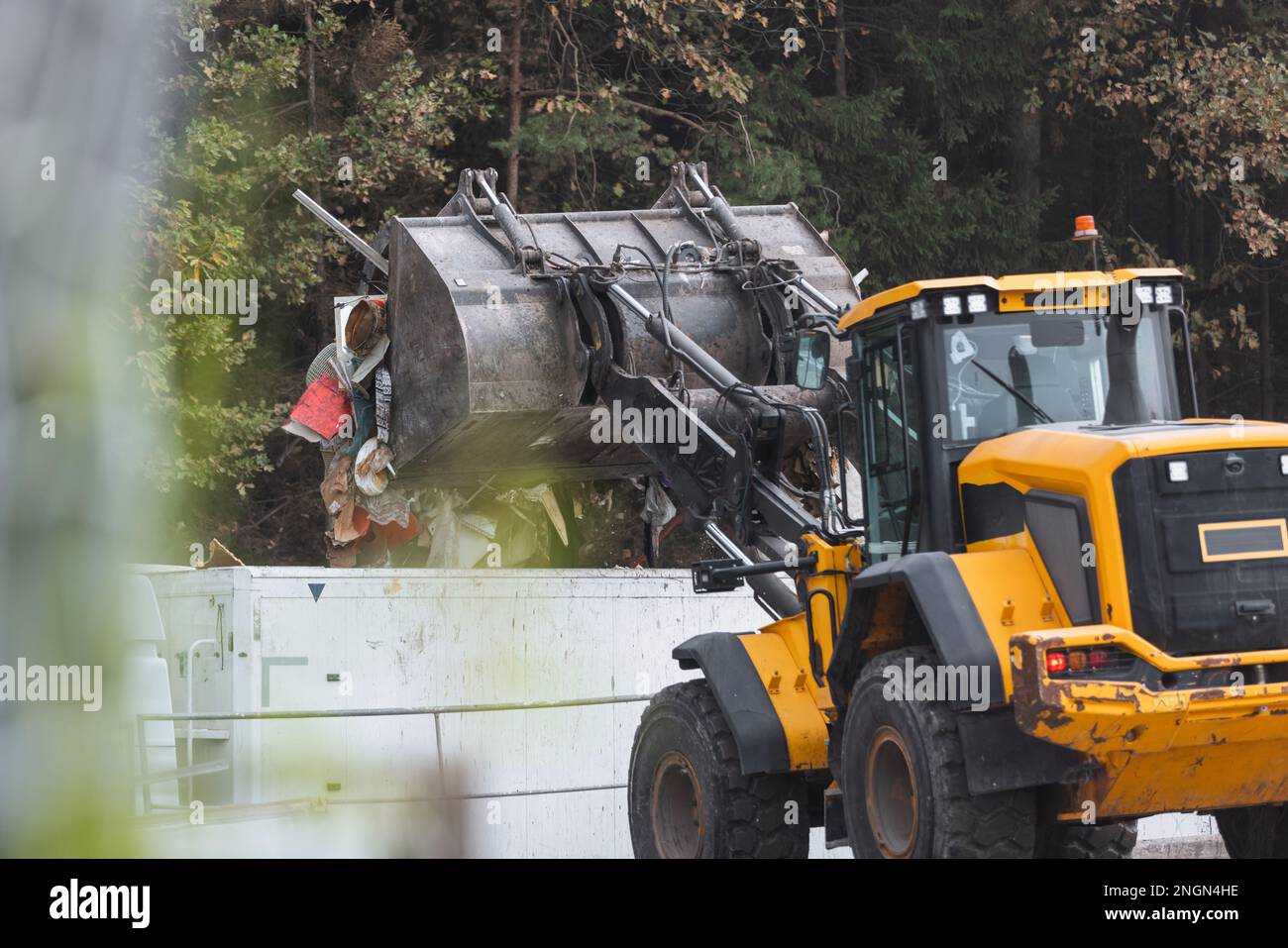 Waste loading operation, loader dumping trash in a truck on a site for ...
