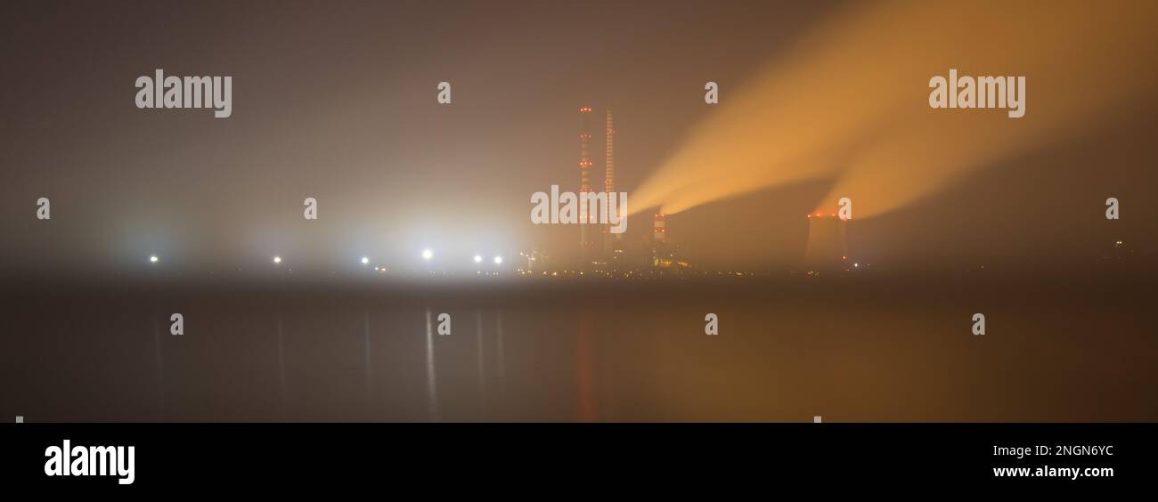 Night over the lagoon with a view of the power plant immersed in fog ...
