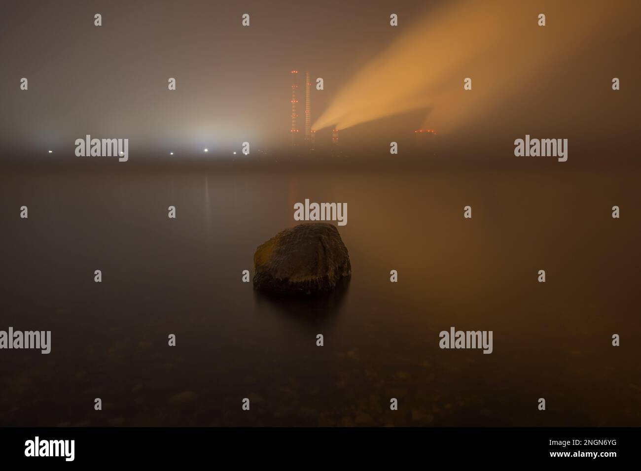 Night over the lagoon with a view of the power plant immersed in fog ...