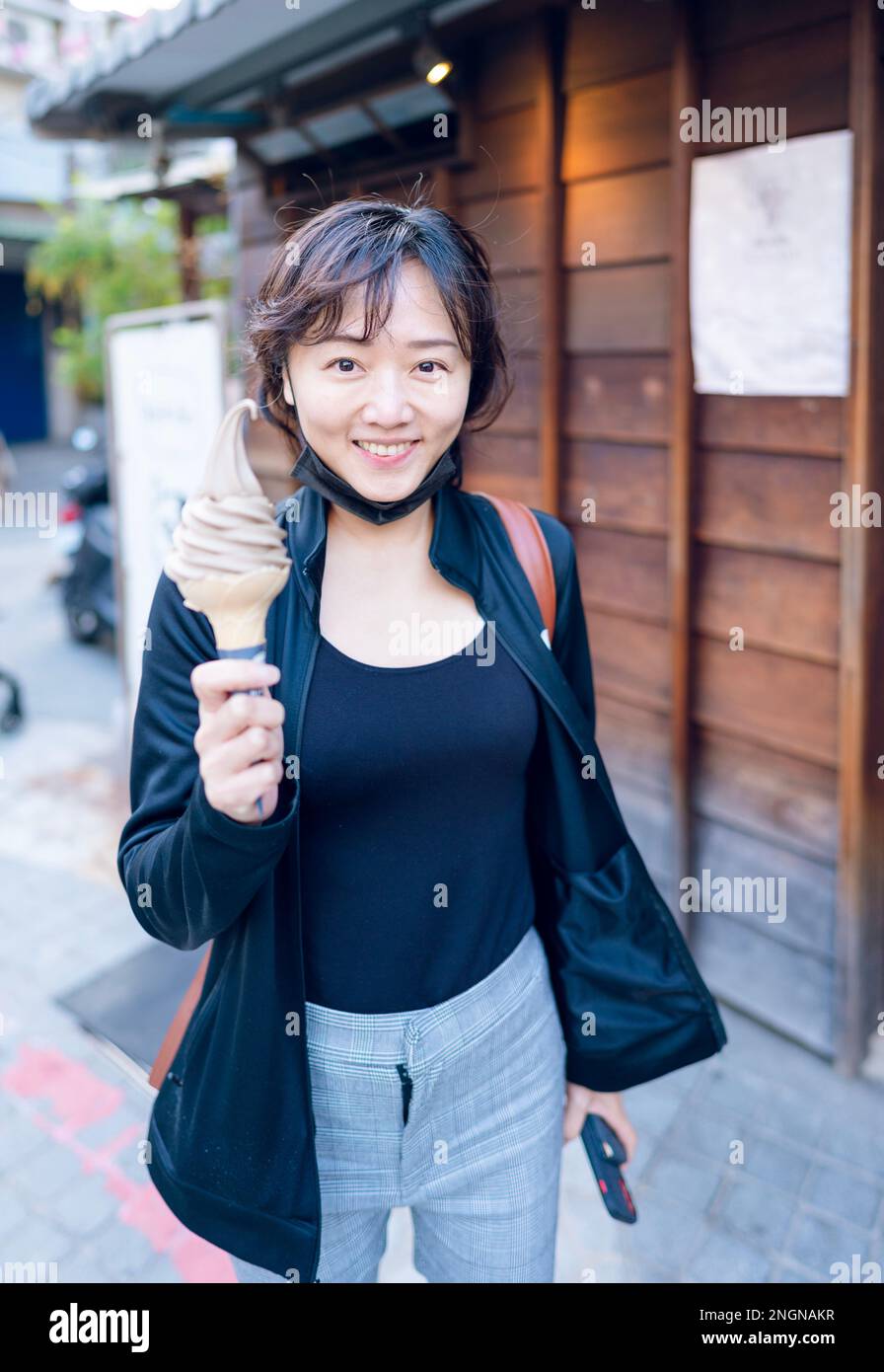 A woman holding a tea-flavored ice cream in southern Taiwan. It was ...