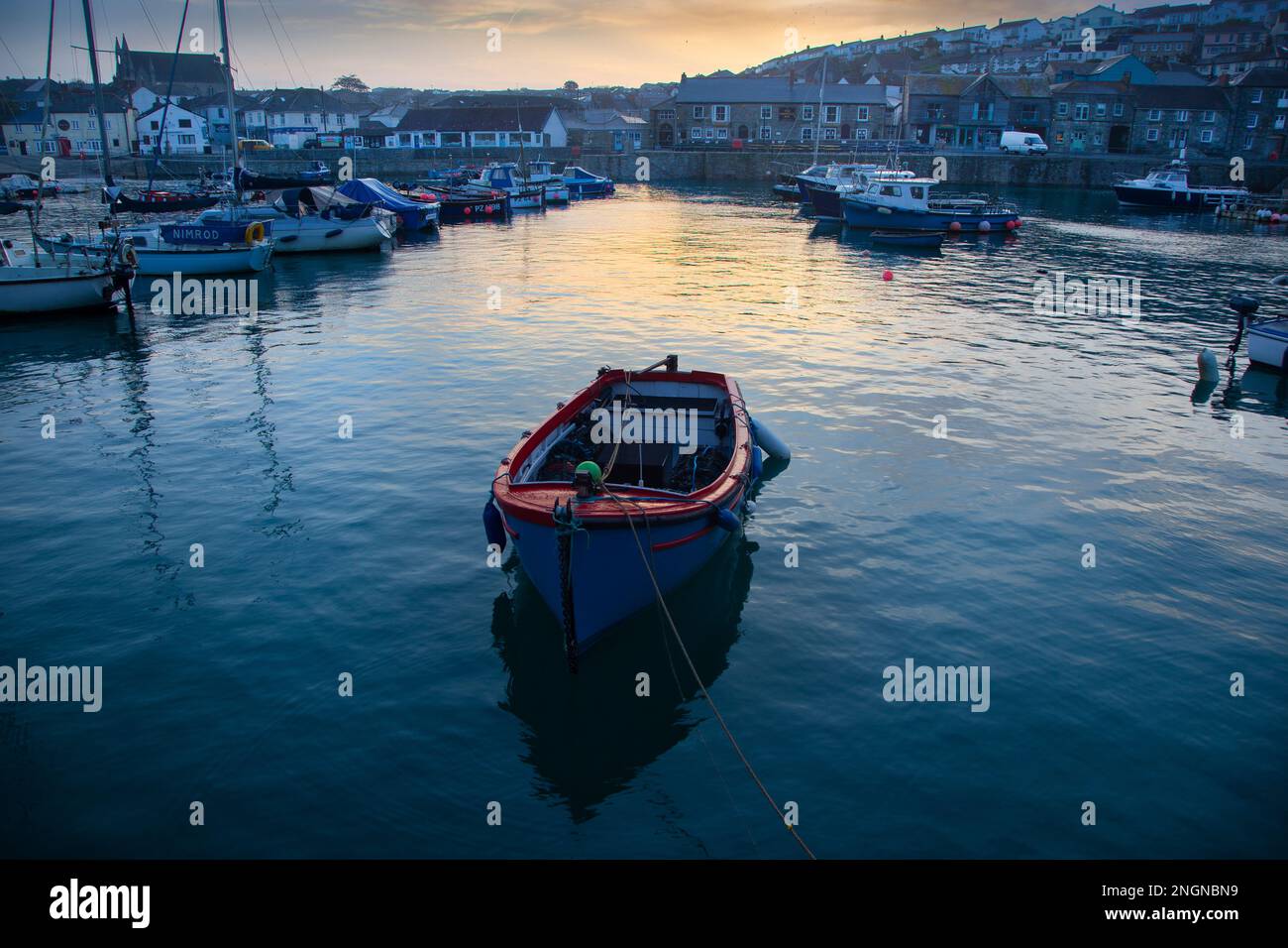 A lone boat in the middle of Porthleven harbour at sunrise Stock Photo ...