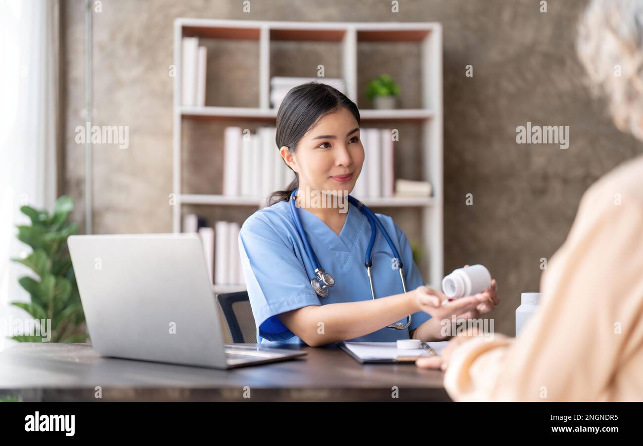 Young nursecaregiver advising contented senior woman on medication in ...