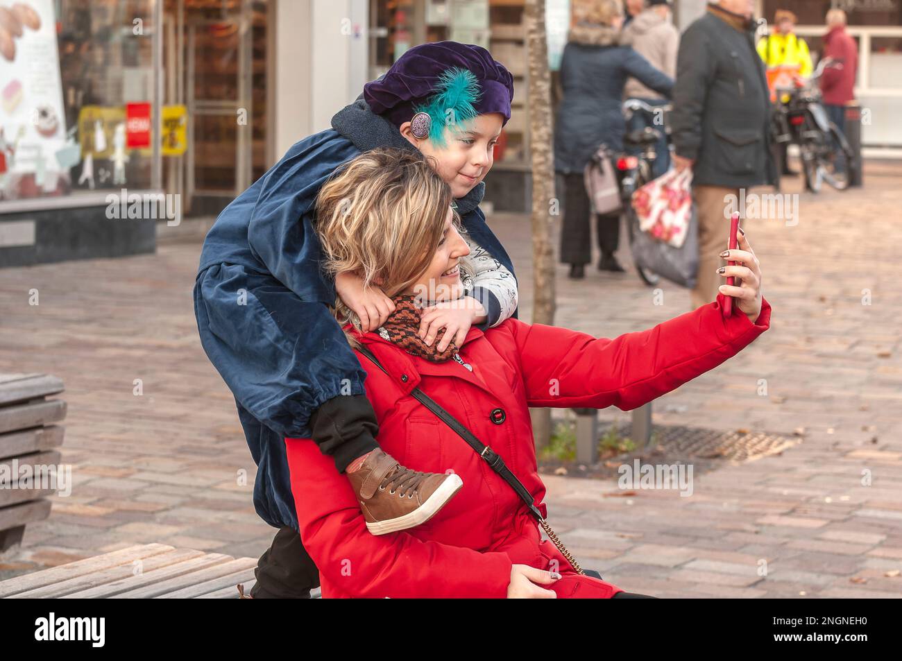 Mother takes a picture with her cell phone together with her son who is ...