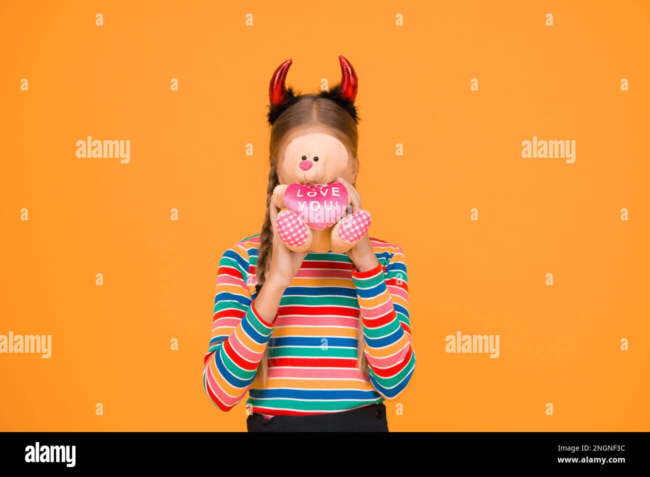 Love you. Small child cover face with teddy bear toy. Little girl in ...