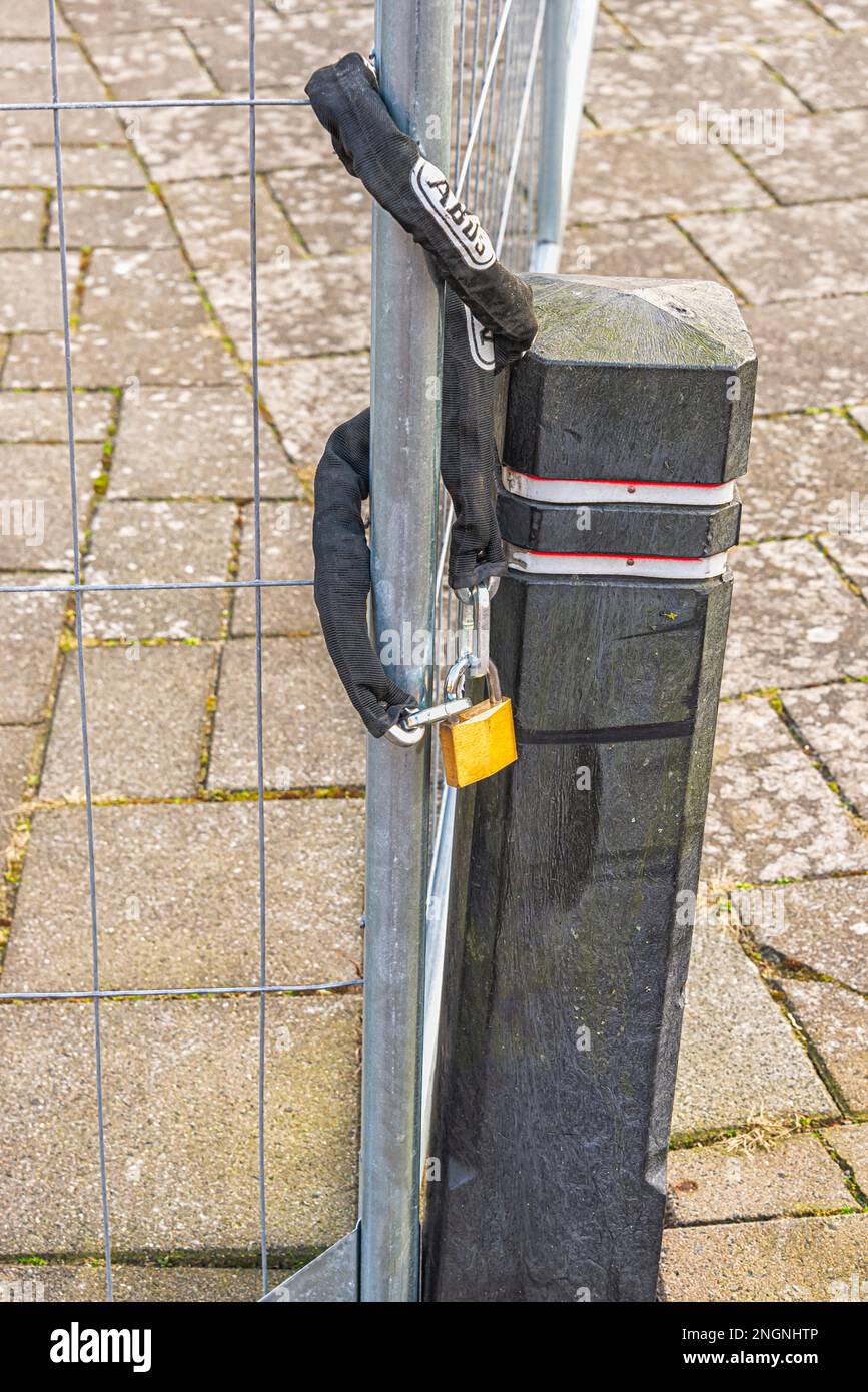 fencing attached to a black plastic post by means of a lock chain Stock ...