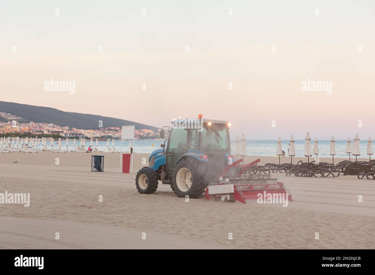 Tractor smoothes the sand on public beach by the sea Stock Photo - Alamy