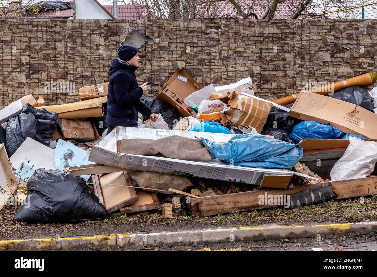 A boy walks on a pavement full of large rubbish as house renovations ...