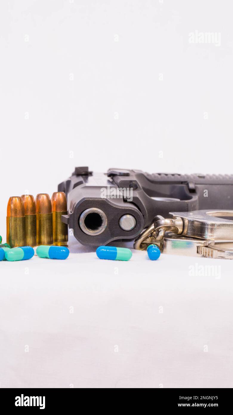 9mm pistol, bullets, clip, handcuffs and drugs with copy space ...
