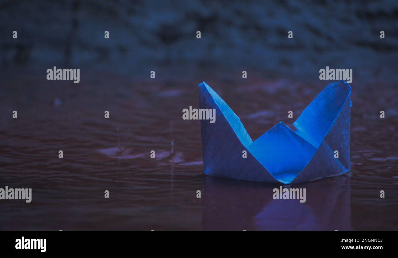 A sheet of origami paper on a water surface, sunlit background Stock ...