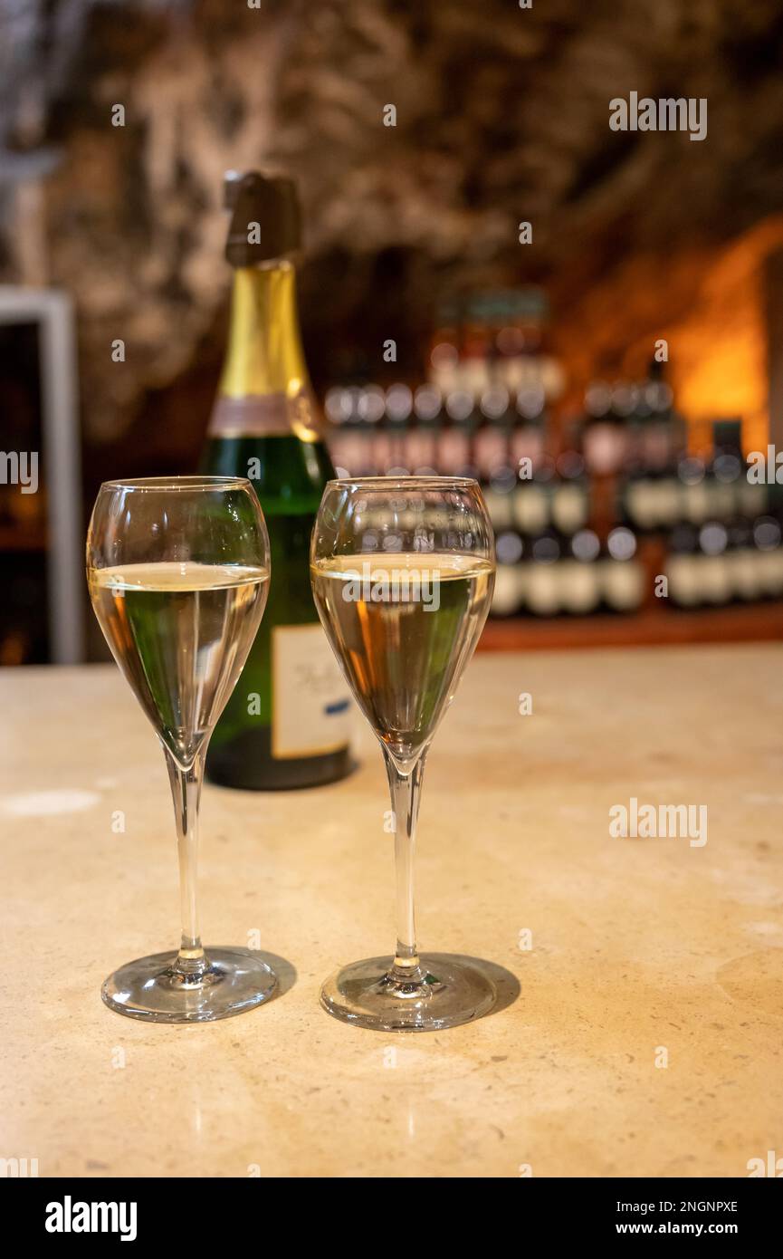 Tasting of rose champagne sparkling wine produced by traditional method in dark underground ...