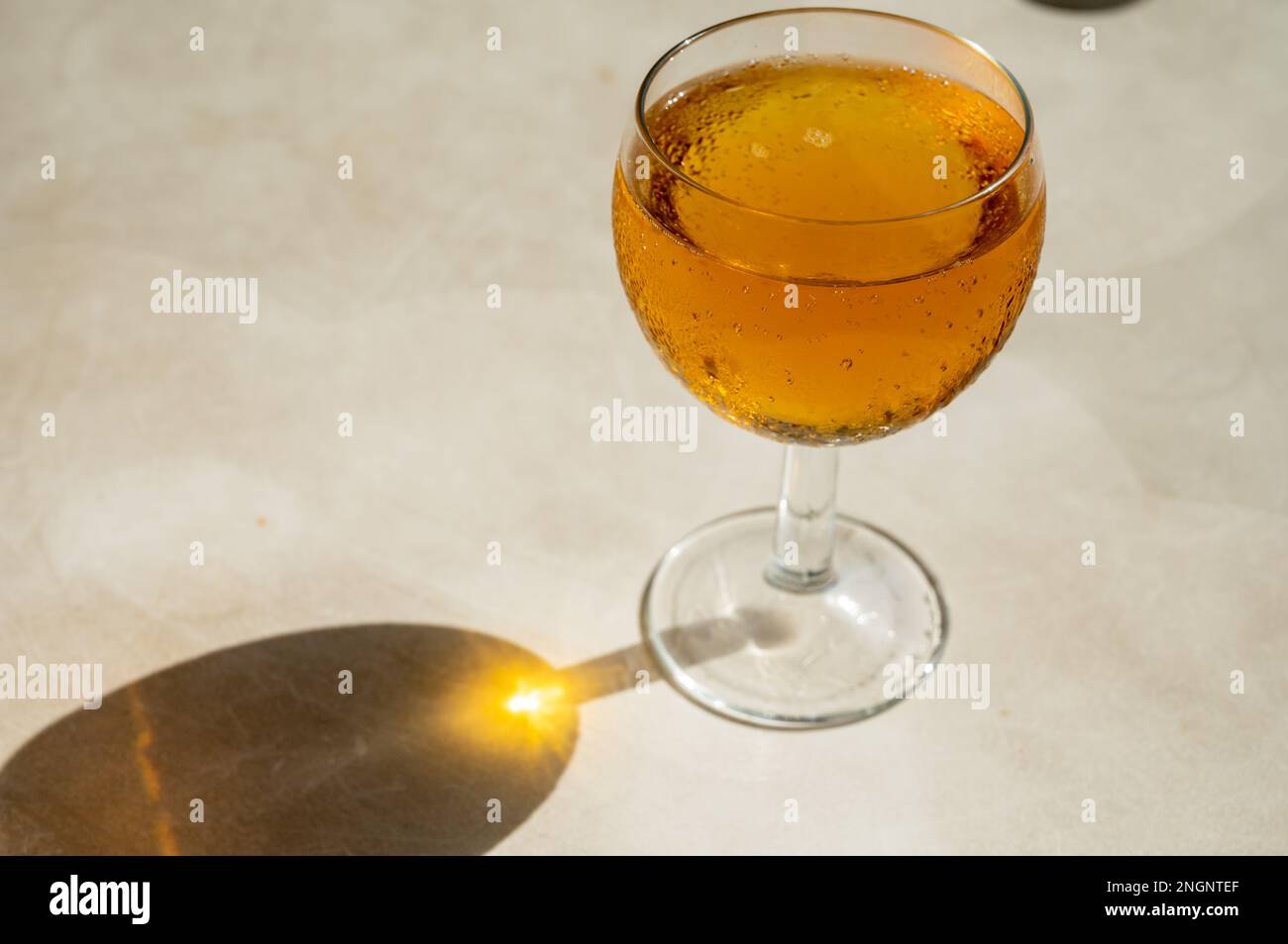 Glass of of French apple sparkling cider on plastic table in outdoor ...