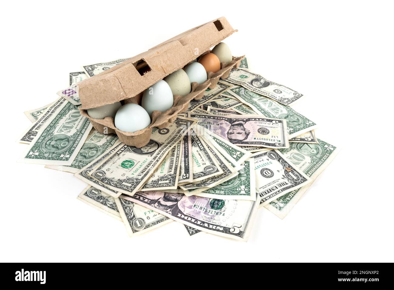 Half open Brown carton of farm fresh eggs on a pile of american money ...