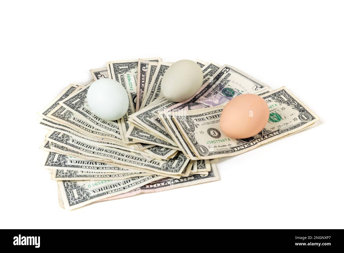 Three farm fresh eggs on a pile of american money Stock Photo - Alamy